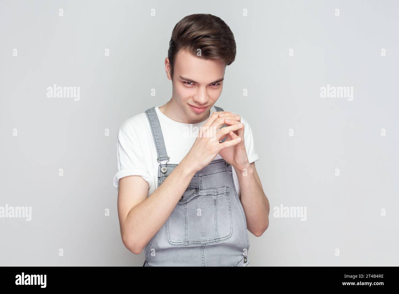 My plan is perfect. Young brunette man schemes something, steepls ...