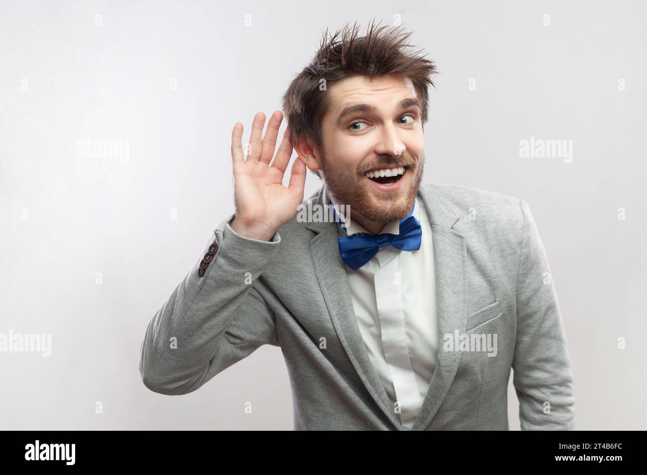 Portrait of smiling positive curious bearded man standing hand near ear ...
