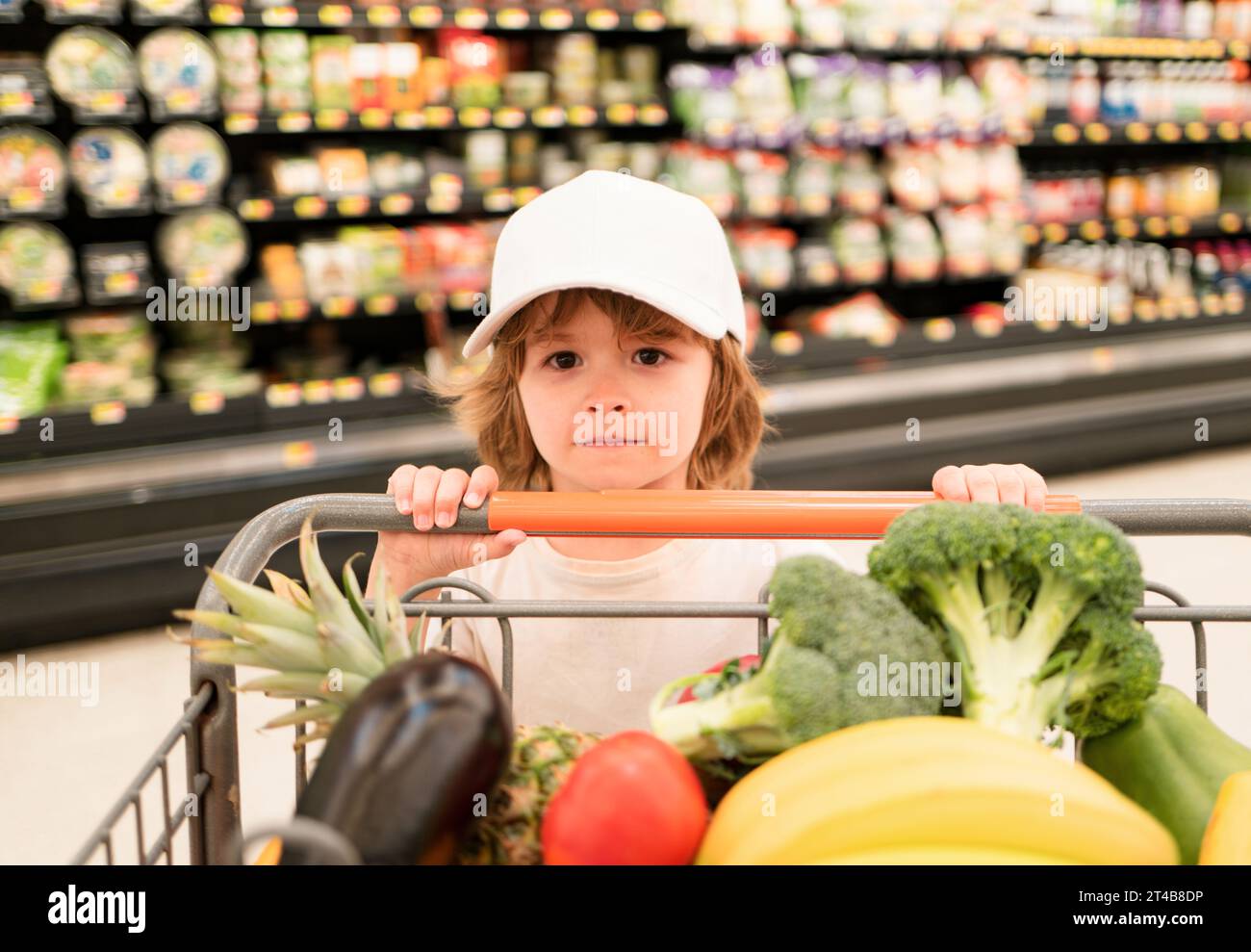 A boy is shopping in a supermarket. Funny customer boy child holdind ...