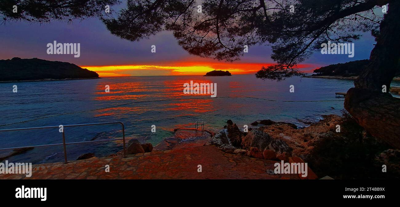 A tranquil scene of a dusky sky illuminated by a golden-orange sunset ...