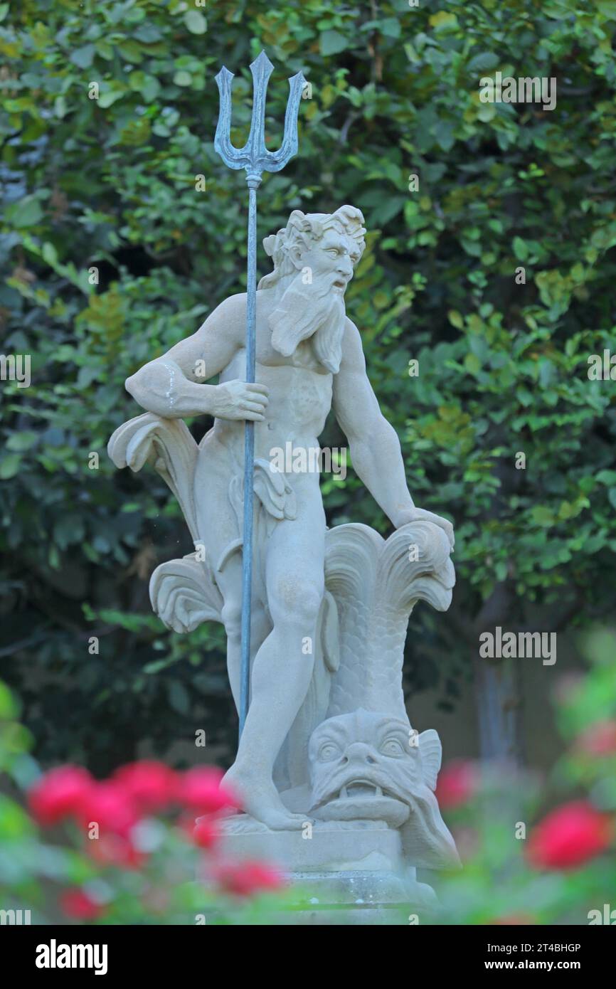 Sculpture Neptune with trident and fish figure in baroque rose garden ...