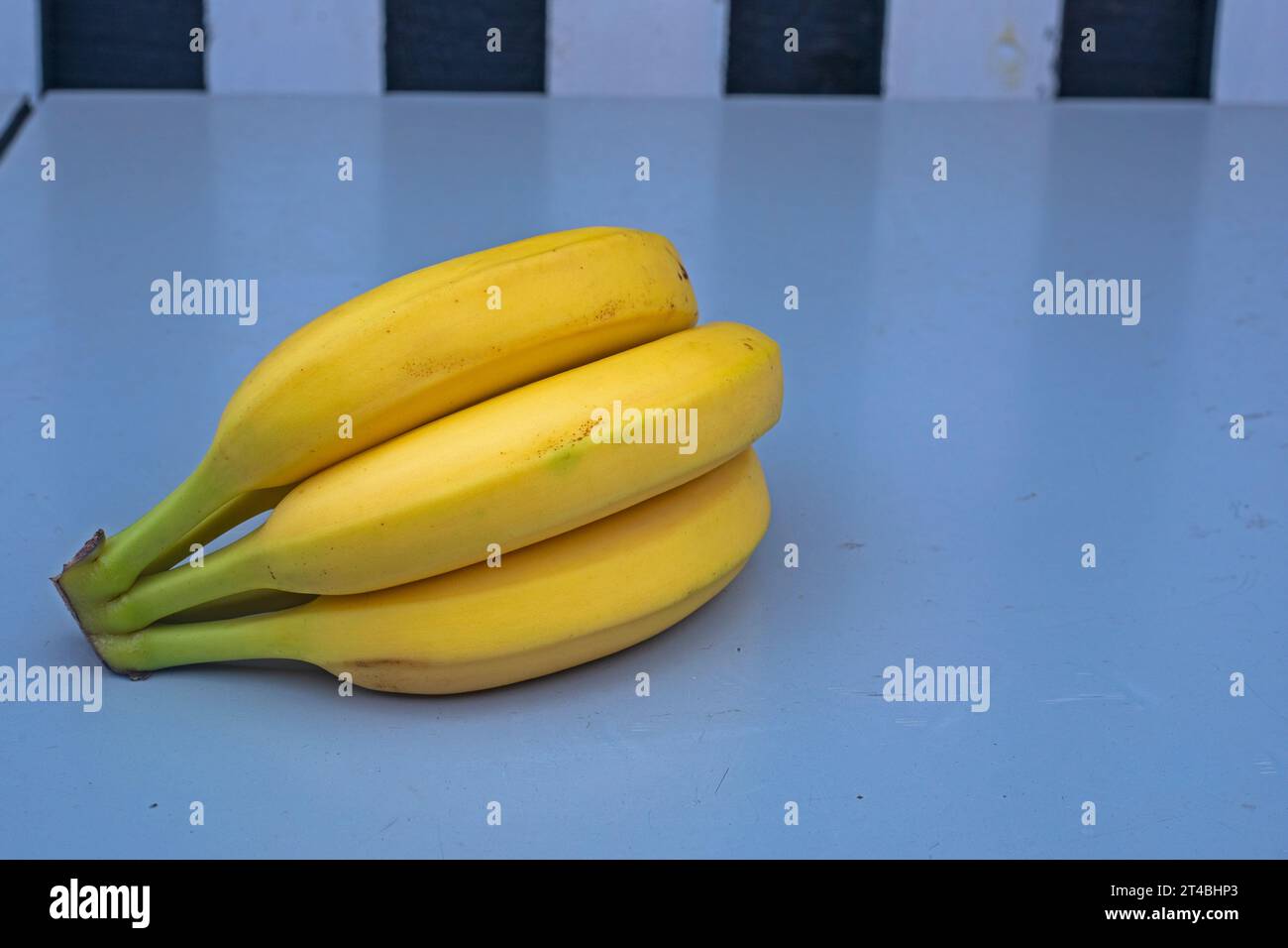 bunch of bananas on a light table on the veranda outside Stock Photo ...