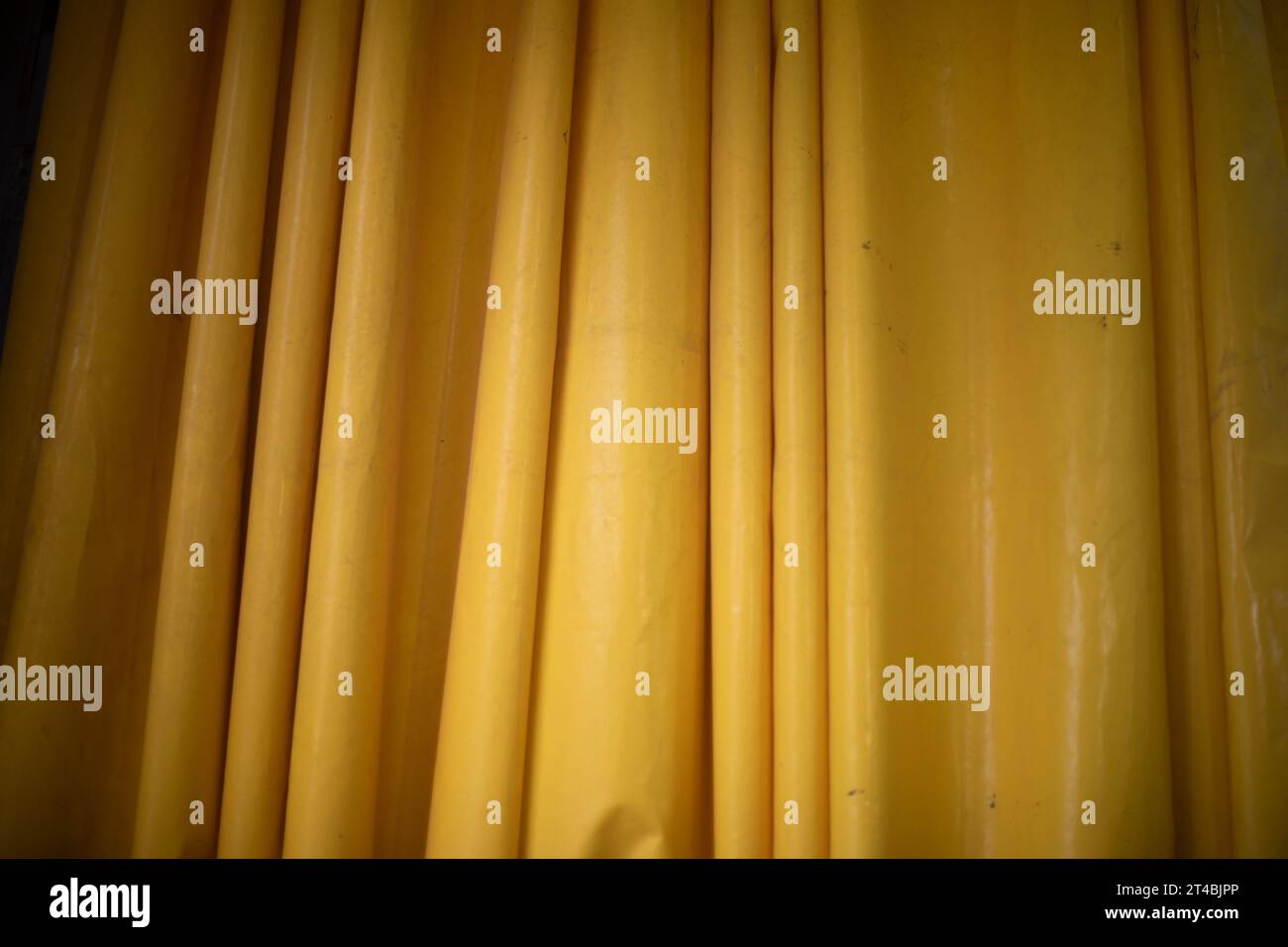 Yellow rubber tarpaulin at car wash. Moisture protection. Texture of ...