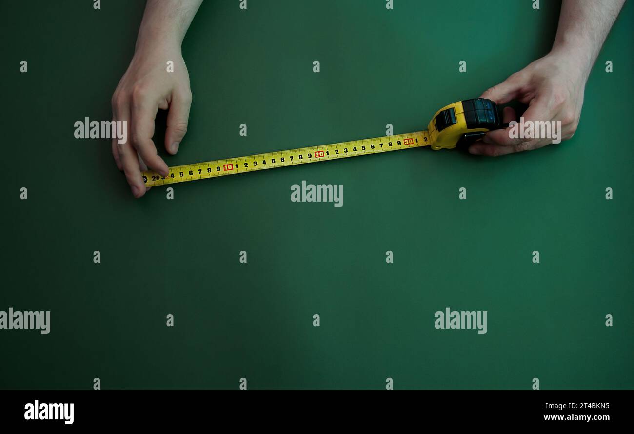 Measuring wooden board with measuring roulette. Yellow measure tape is ...