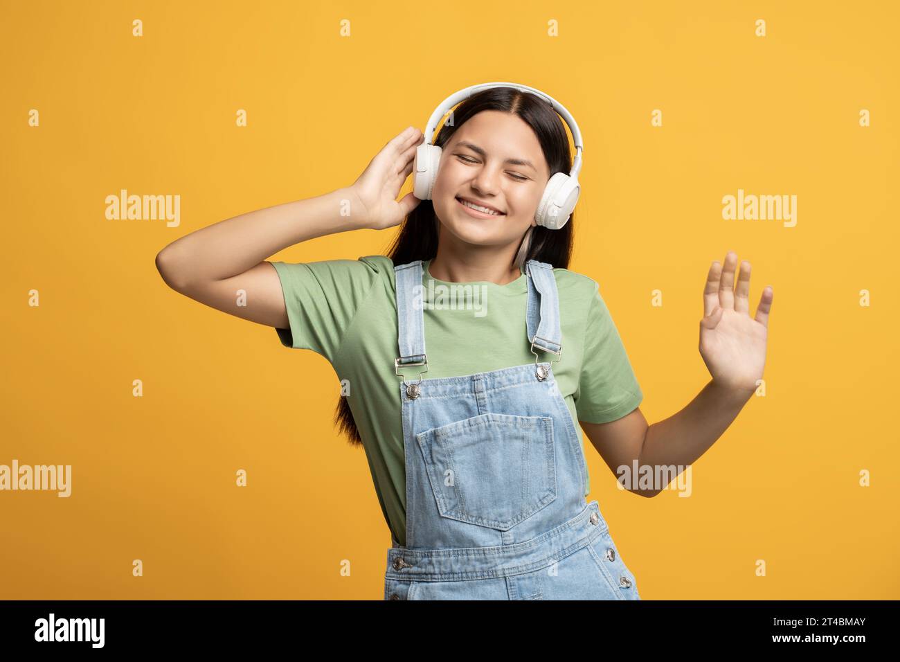 Girl music lover in headphones listening to music dancing with closed ...