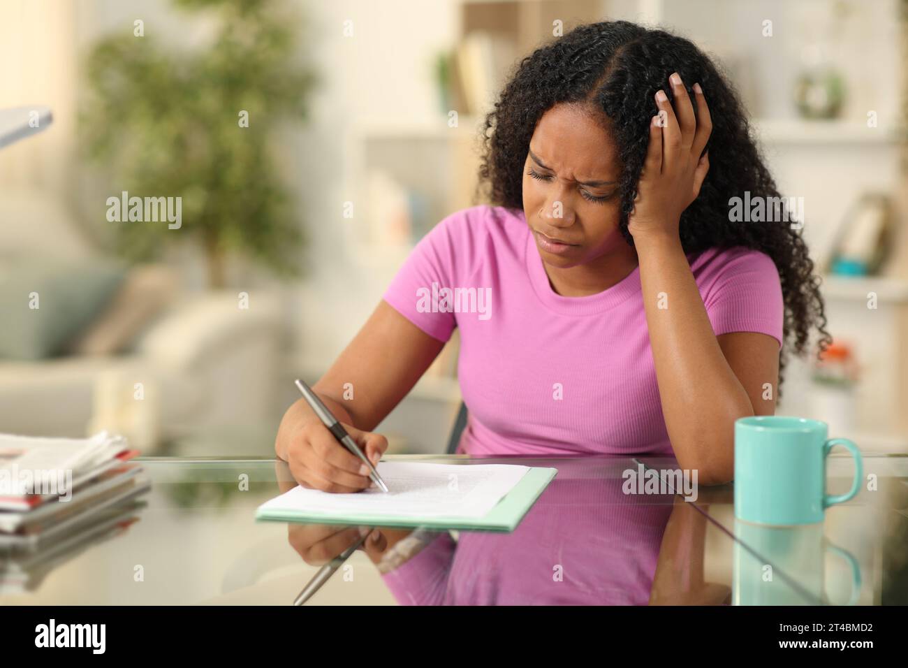 Black sad woman signing form complaining at home Stock Photo - Alamy