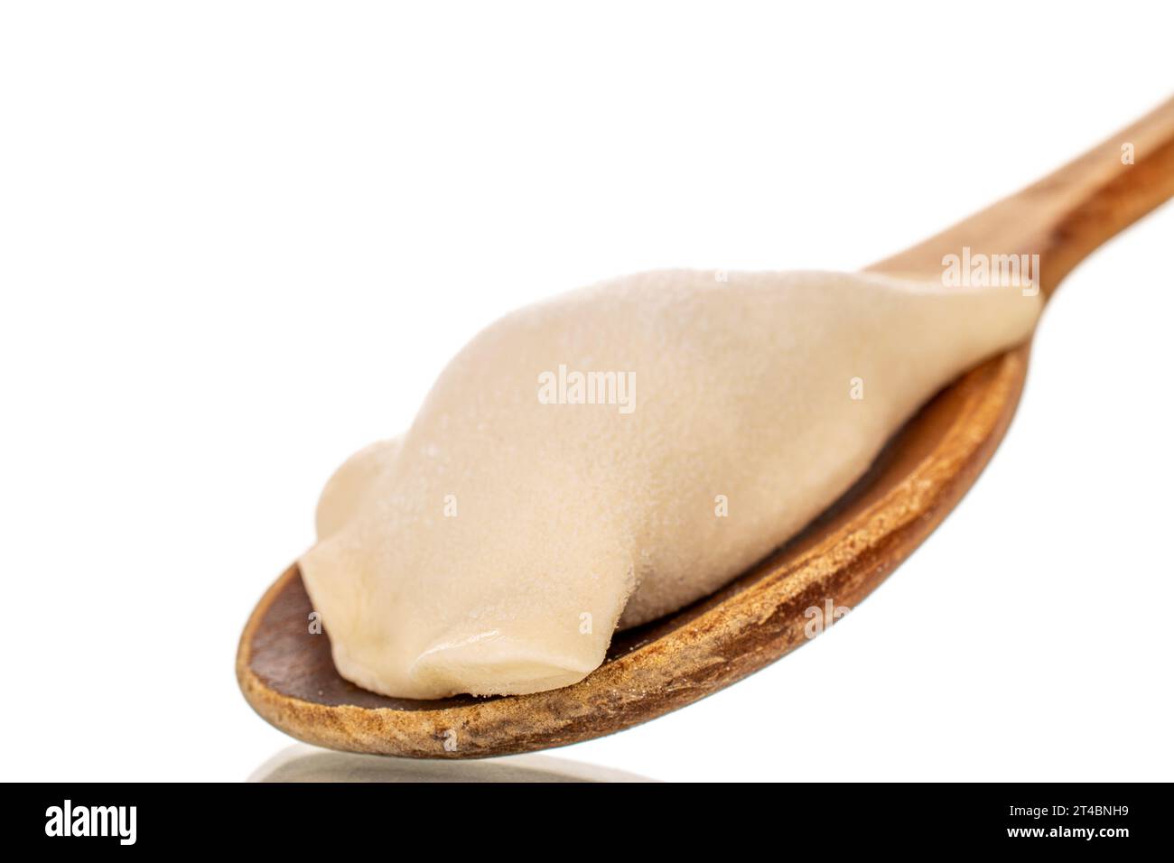One frozen semi-finished dumpling with wooden spoon, macro, isolated on ...