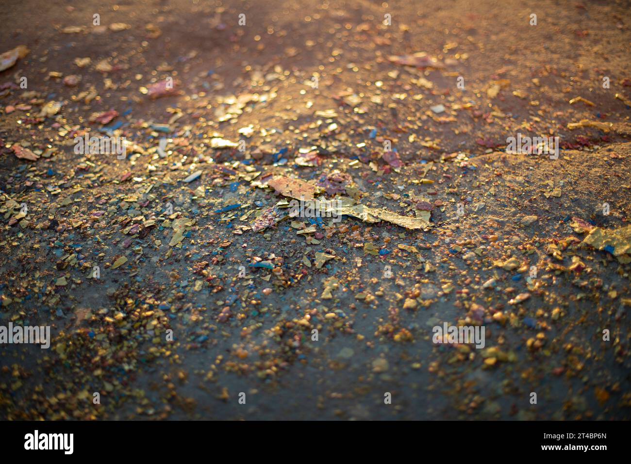 Pieces of paint lie on asphalt. Texture of colored dirt. Small dust ...