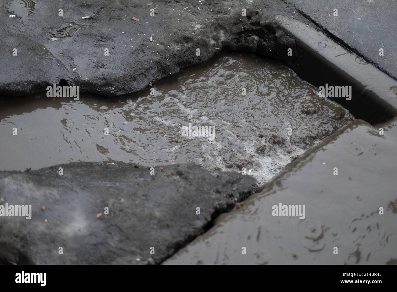 Puddle after rain. Wastewater on street. Dirt in city Stock Photo - Alamy