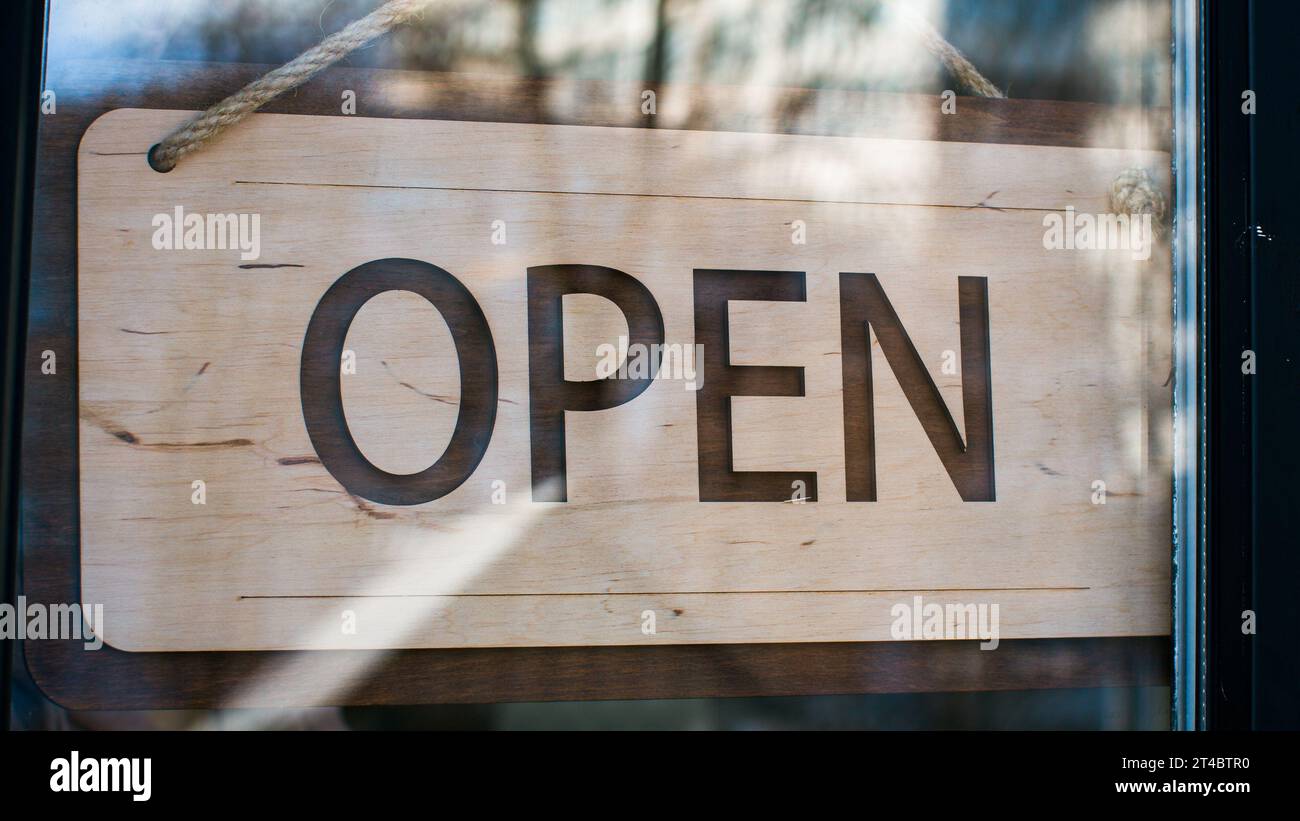 Close-up man waiter salesman turning signboard from closed to open on ...