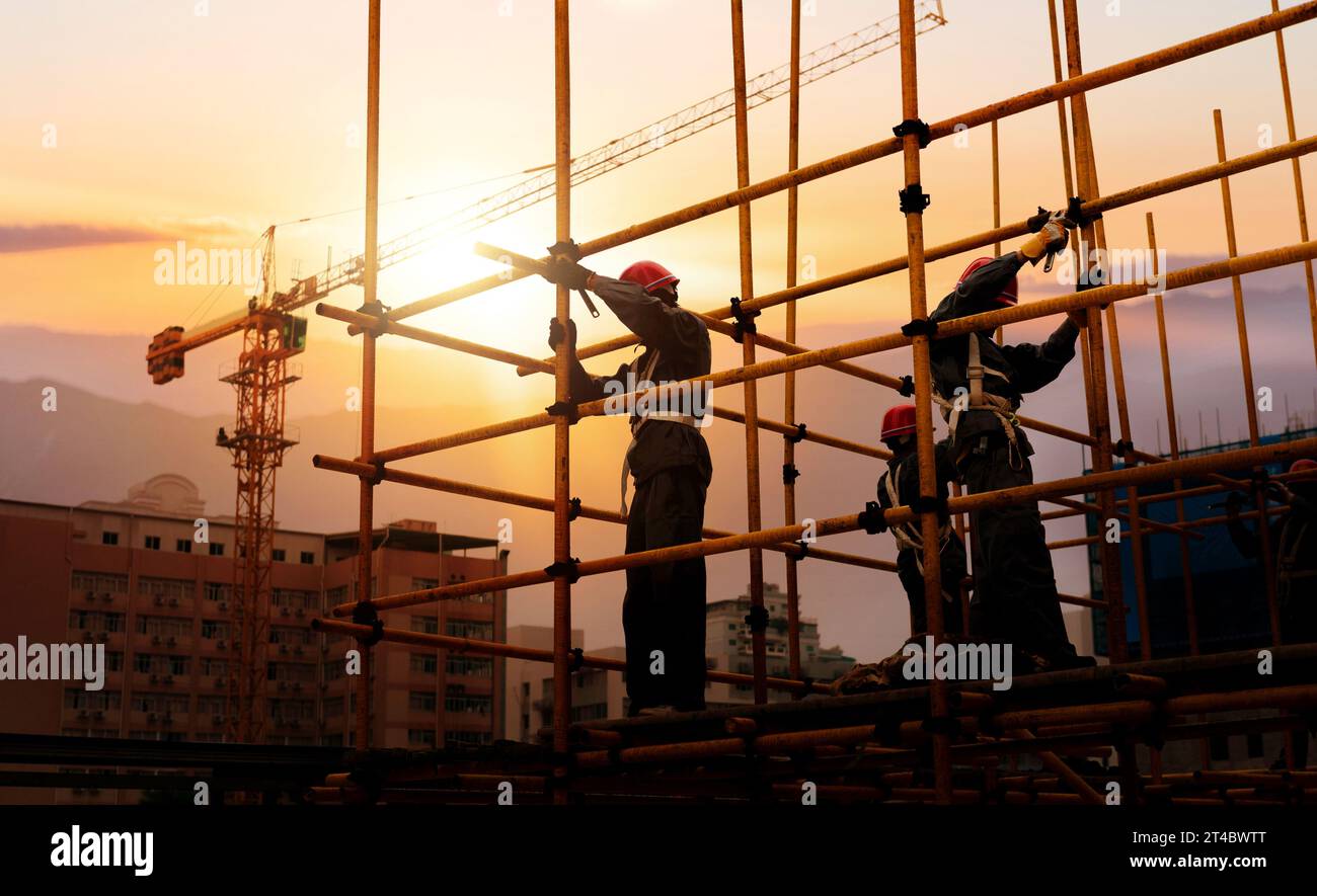 Group of construction workers working on scaffolding Stock Photo - Alamy