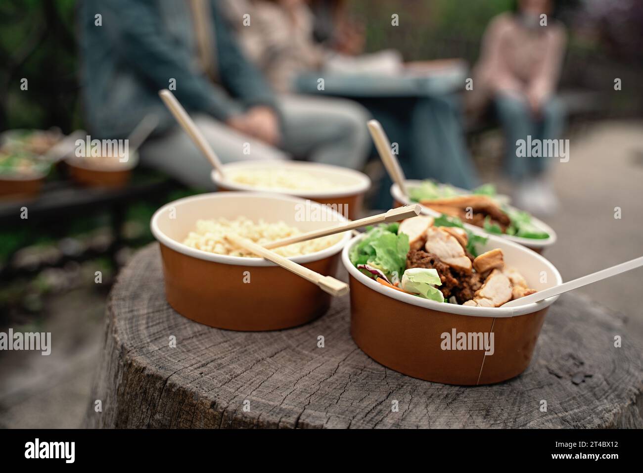 Bowls of noodles and tofu delicacies placed on a rustic wooden surface ...