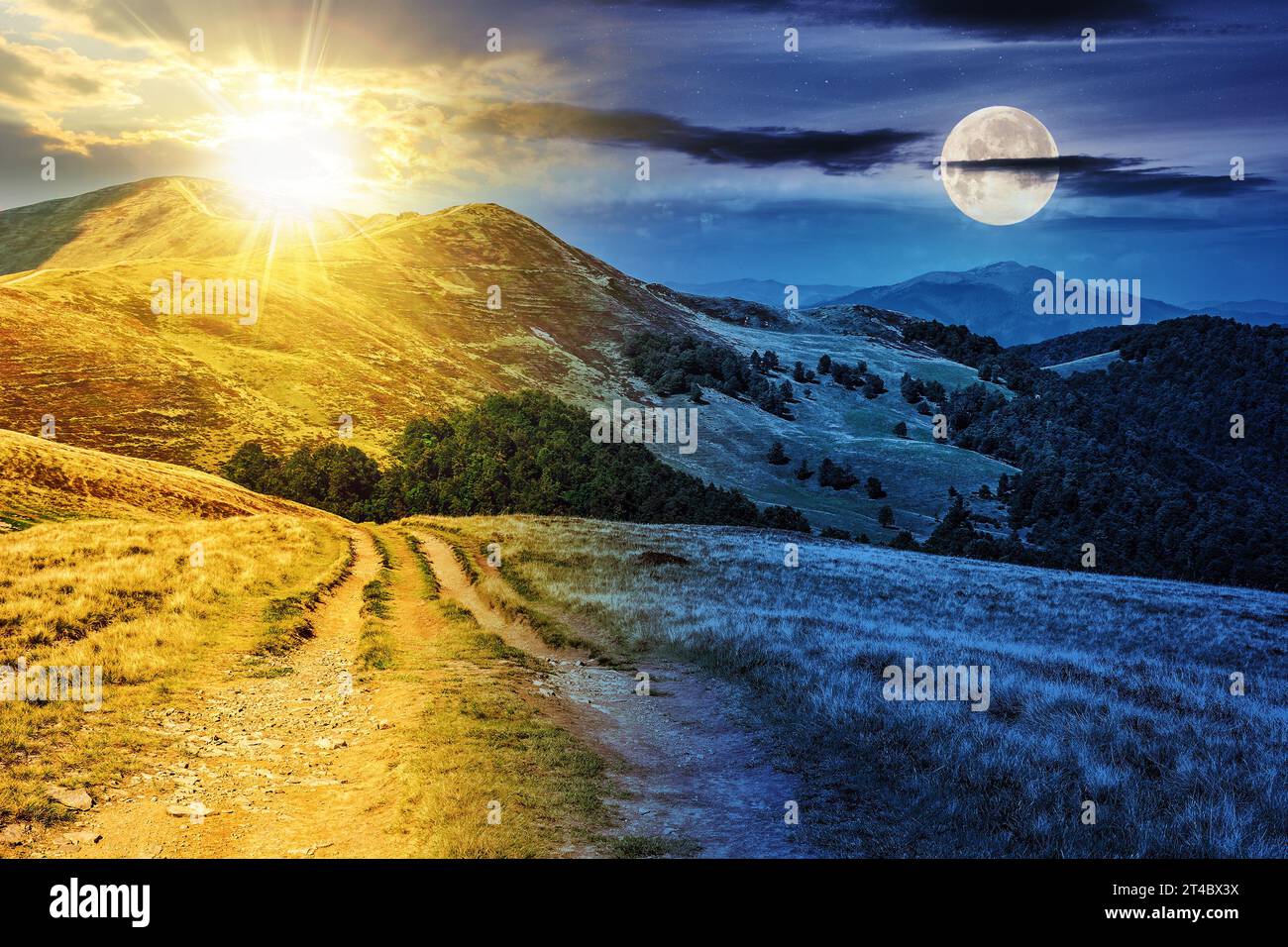 road through large meadow on the hill of mountain range with sun and ...