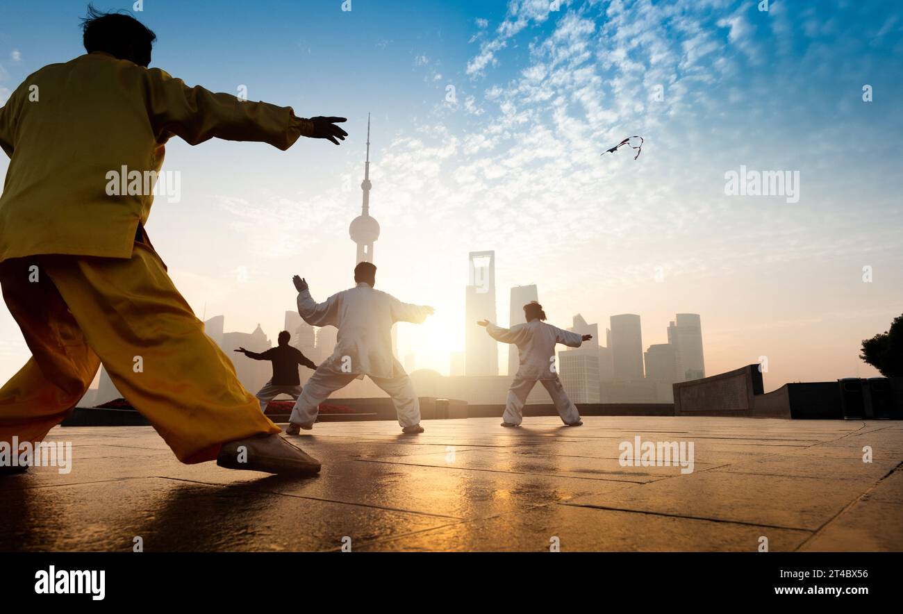 People practice taiji on the bund, oriental pearl tower in the distance ...
