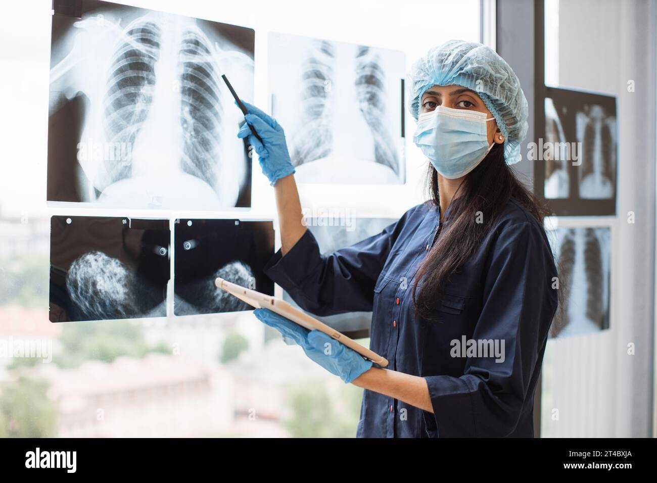 Female worker posing with digital tablet near x-ray scans Stock Photo ...