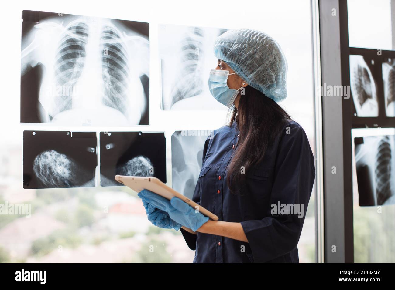 Female worker posing with digital tablet near x-ray scans Stock Photo ...