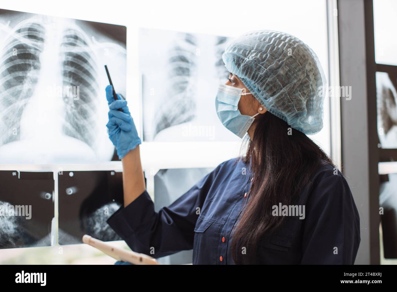 Female worker posing with digital tablet near x-ray scans Stock Photo ...