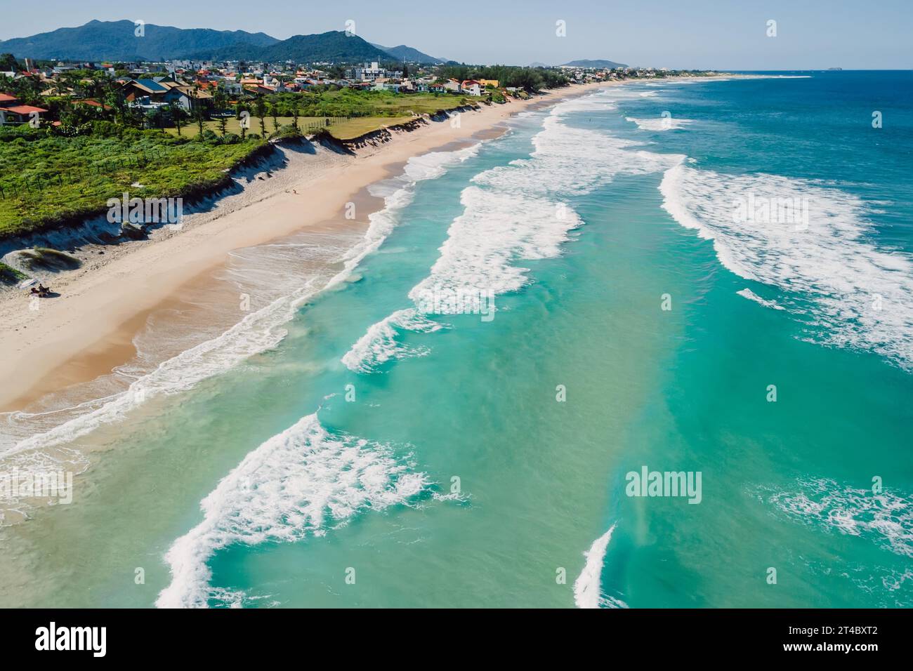Beach and blue ocean with surfing waves in Brazil. Aerial view of Morro ...