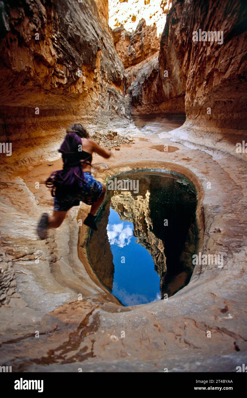 Woman jumping into pool in desert canyon, Grand Canyon, Arizona Stock ...