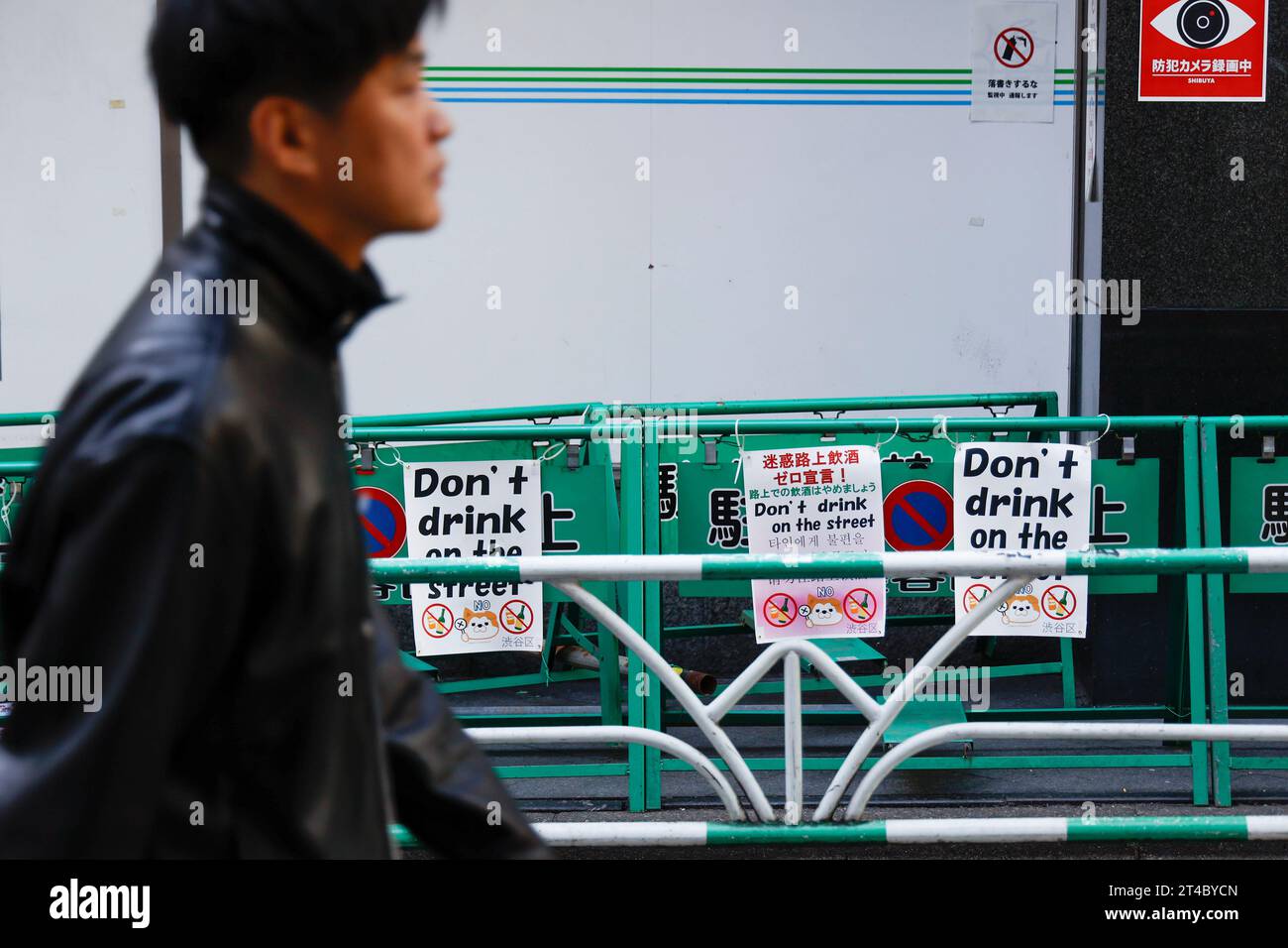 Tokyo, Japan. 30th Oct, 2023. A man walks past signboards displaying a ...