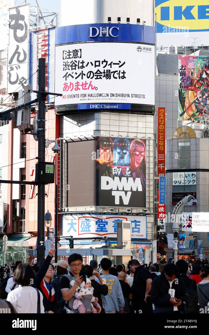 Tokyo, Japan. 30th Oct, 2023. Pedestrians walk past a screen displaying ...