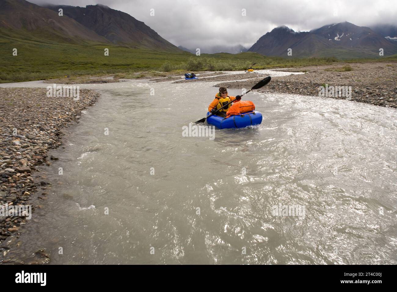 Woman floating down a river in a very small raft in Denali National ...