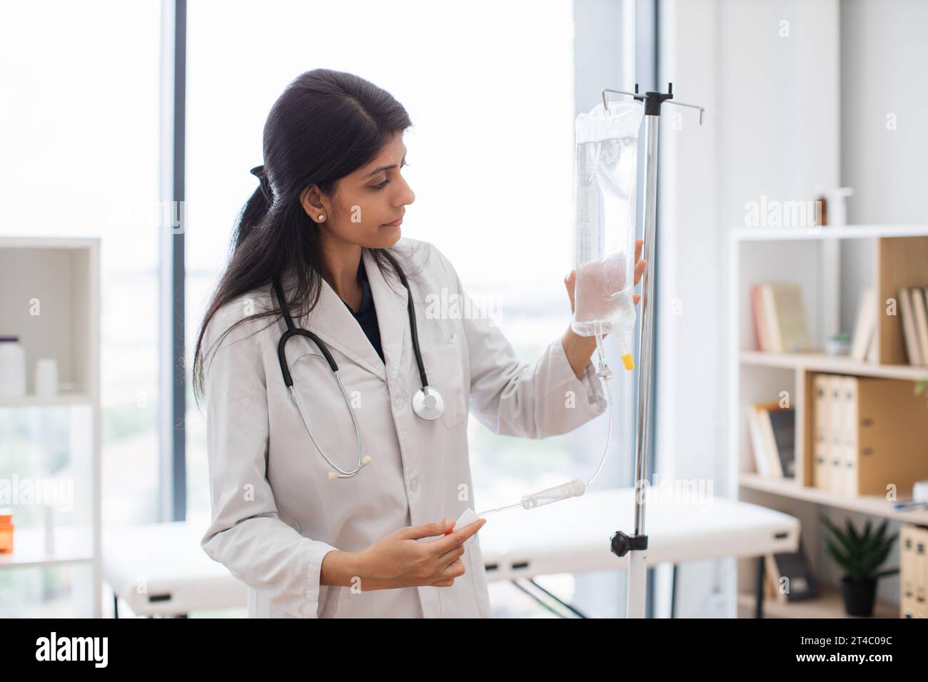 Adult female doctor in white lab coat standing near medical dropper and ...