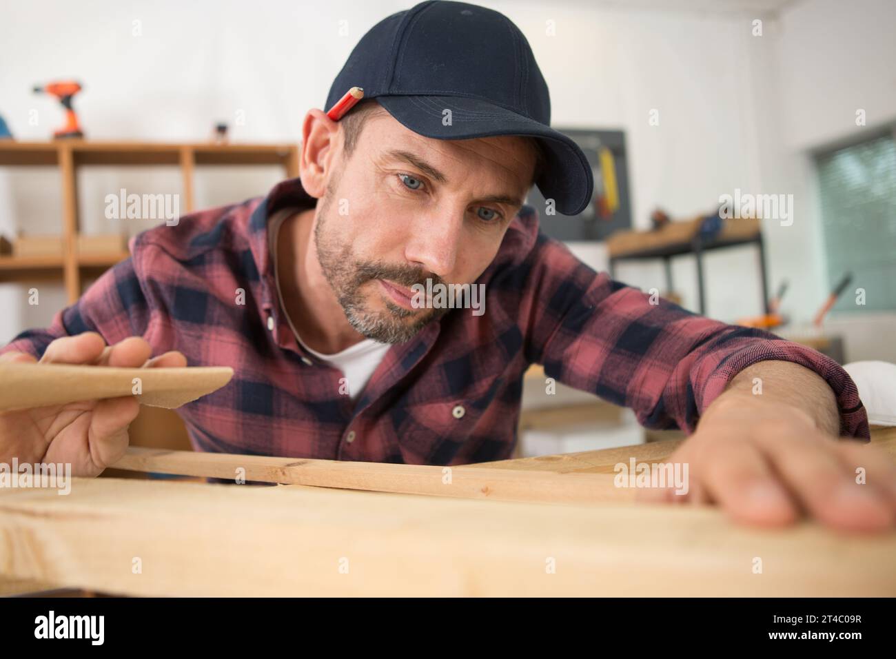 portrait of skilled carpenter polishing piece of wood in workshop Stock ...