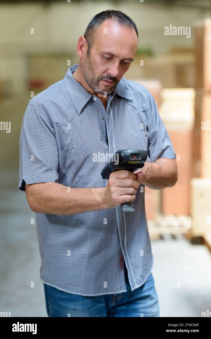 warehouse worker programming handheld scanner Stock Photo - Alamy