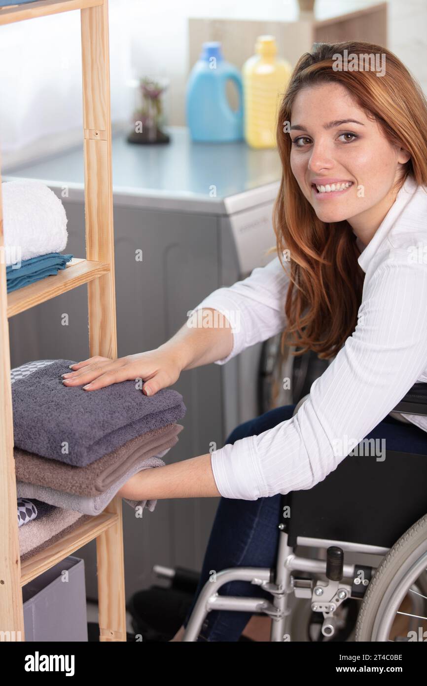 young disabled woman on wheelchair tidying up clean laundry Stock Photo - Alamy