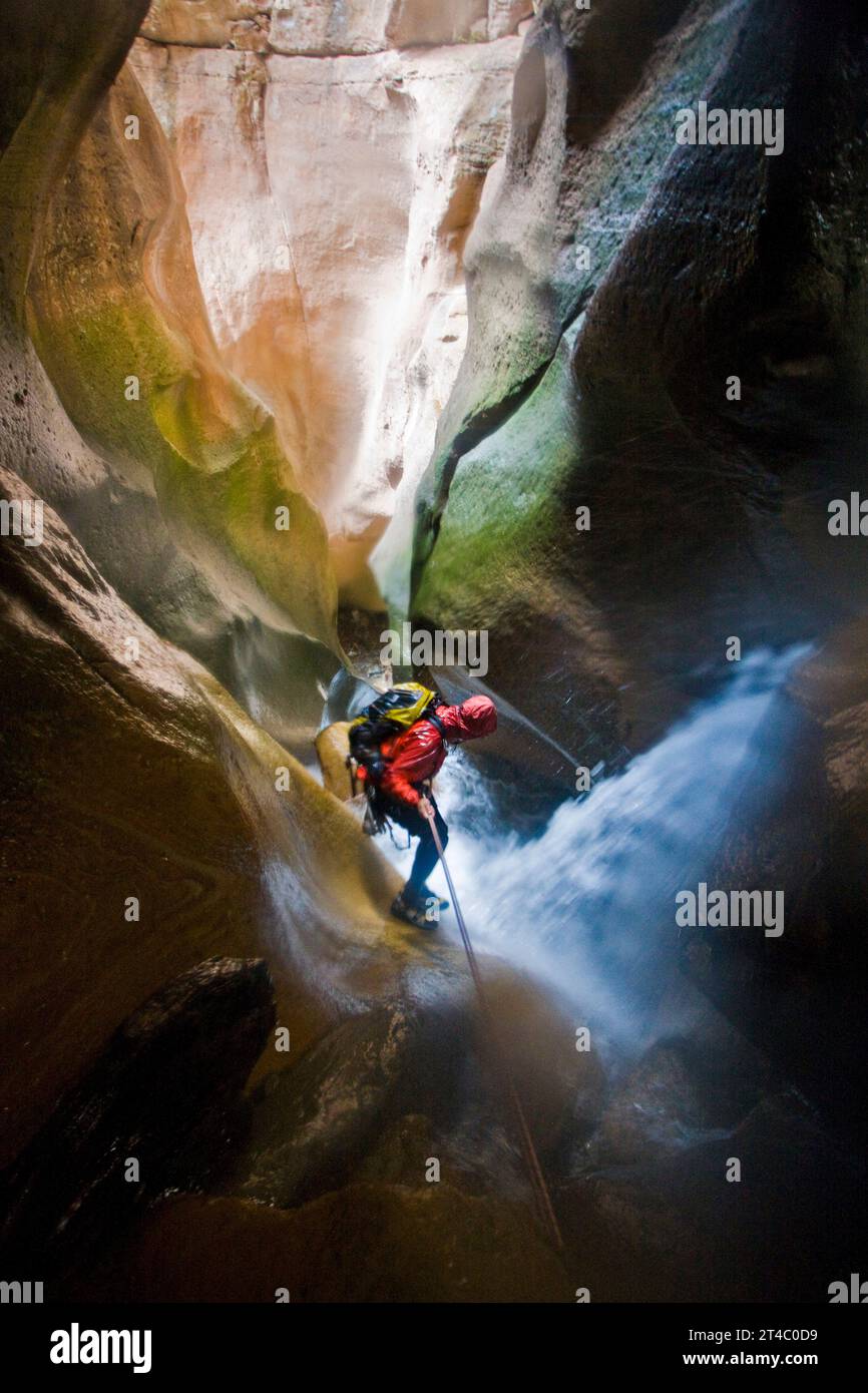Man rappelling down canyon through waterfall in Utah Stock Photo - Alamy