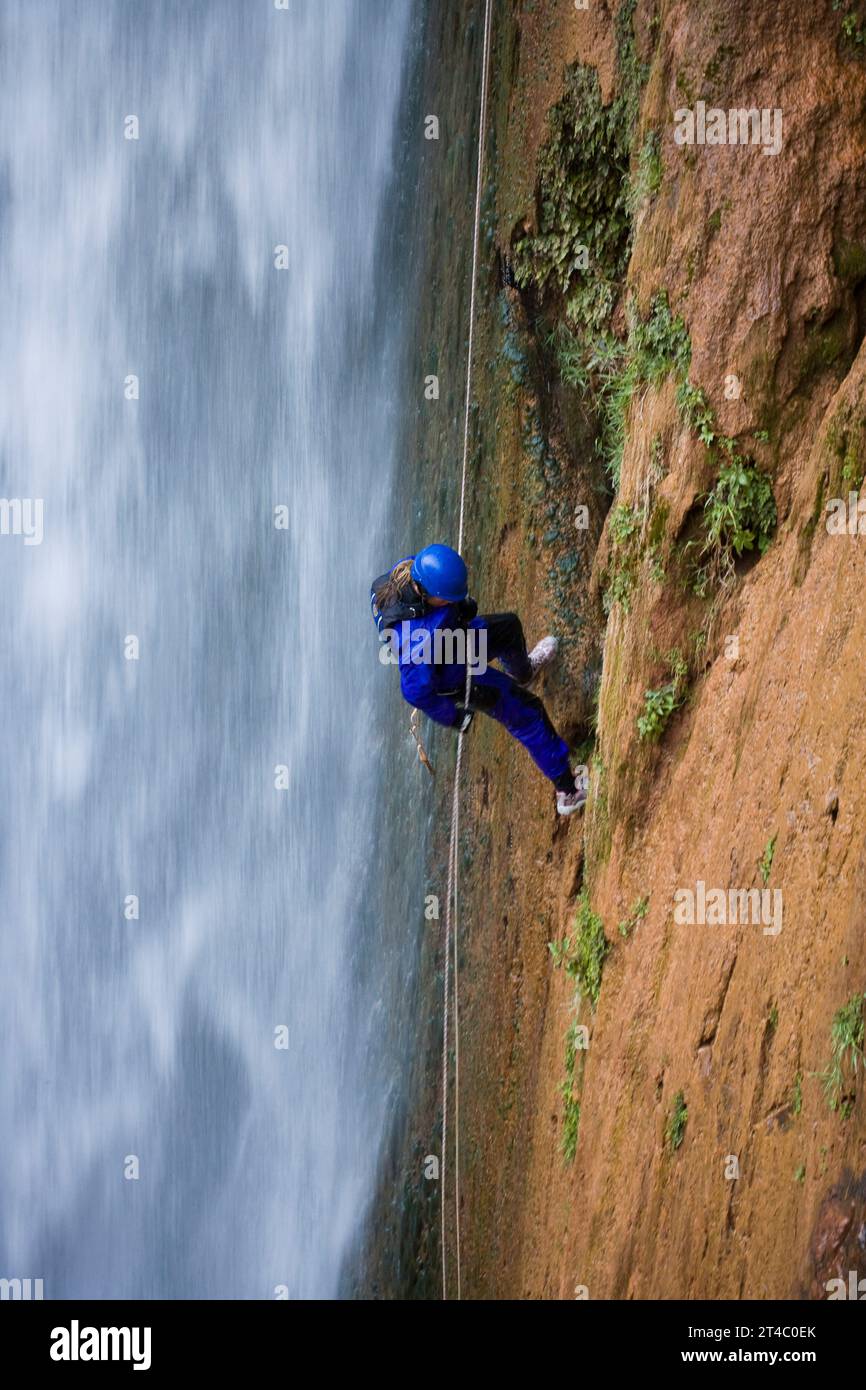 A woman rappelling down next to Deer Creek Falls, Grand Canyon, Arizona ...