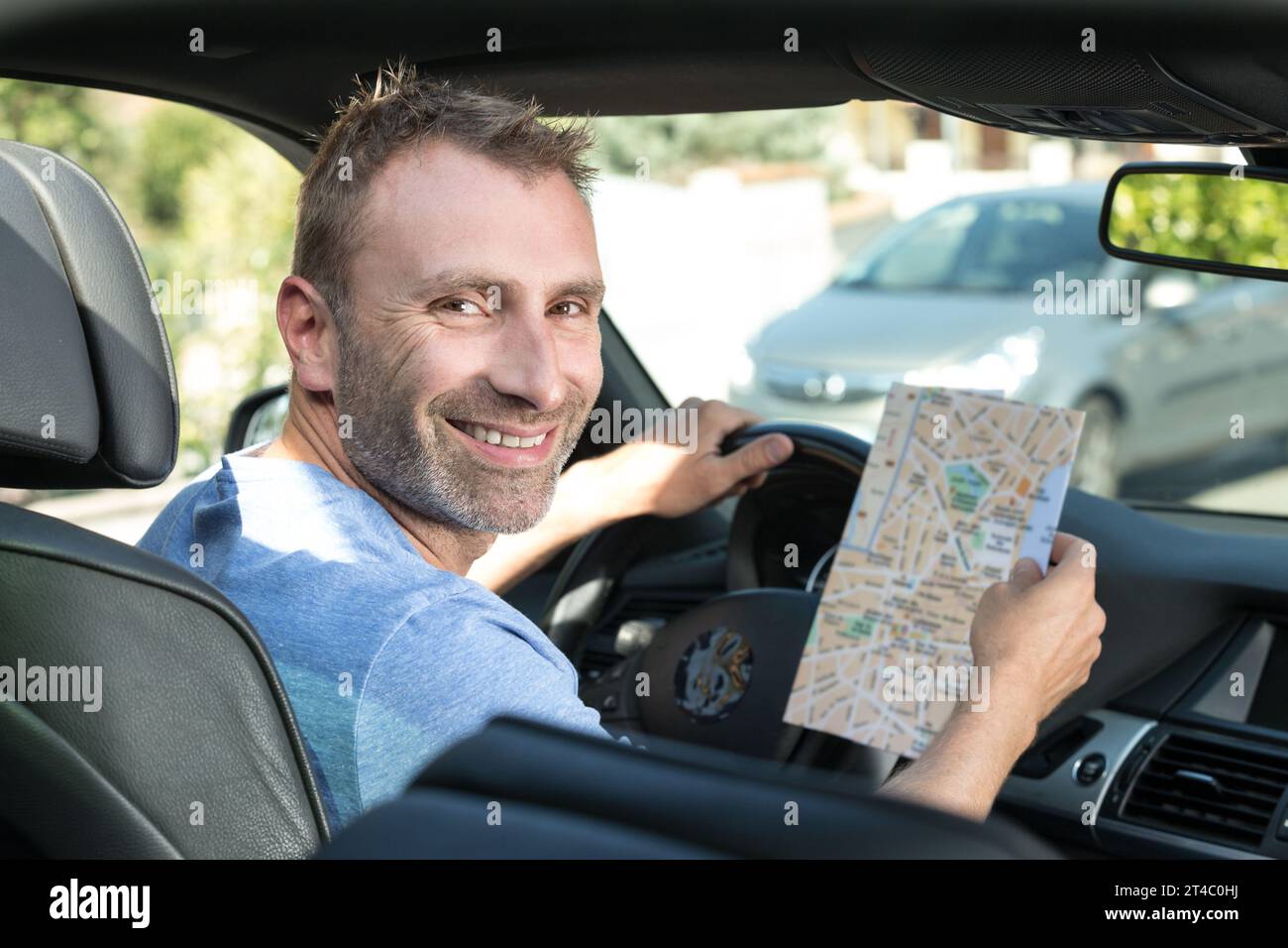 happy man with the map in the car Stock Photo - Alamy