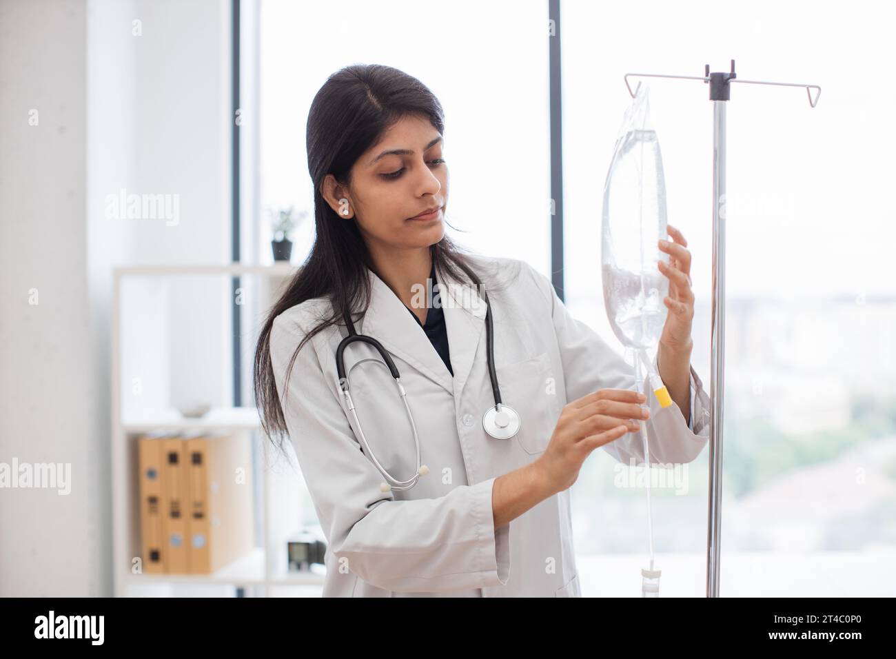 Adult female doctor in white lab coat standing near medical dropper and ...