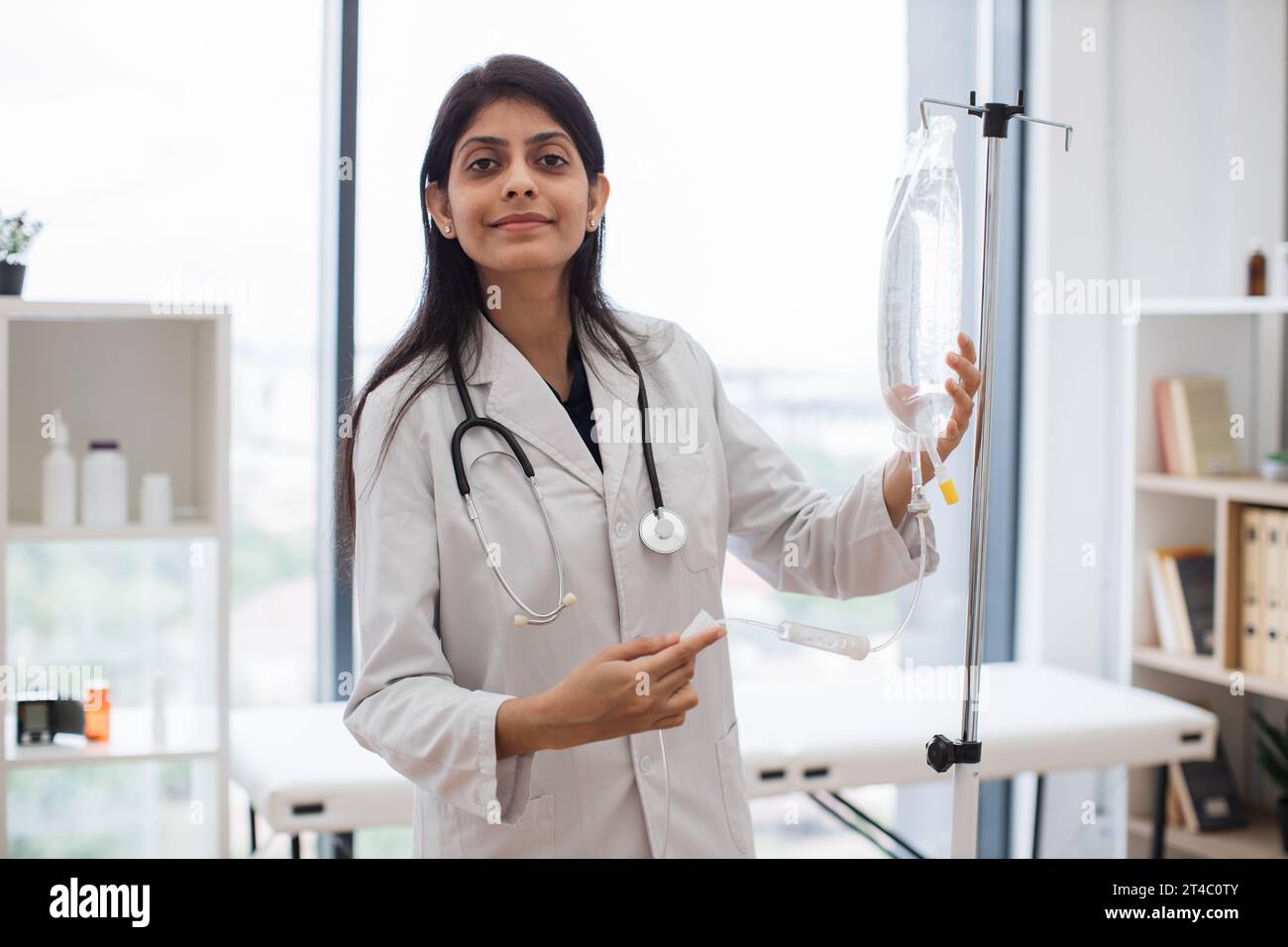 Adult female doctor in white lab coat standing near medical dropper and ...