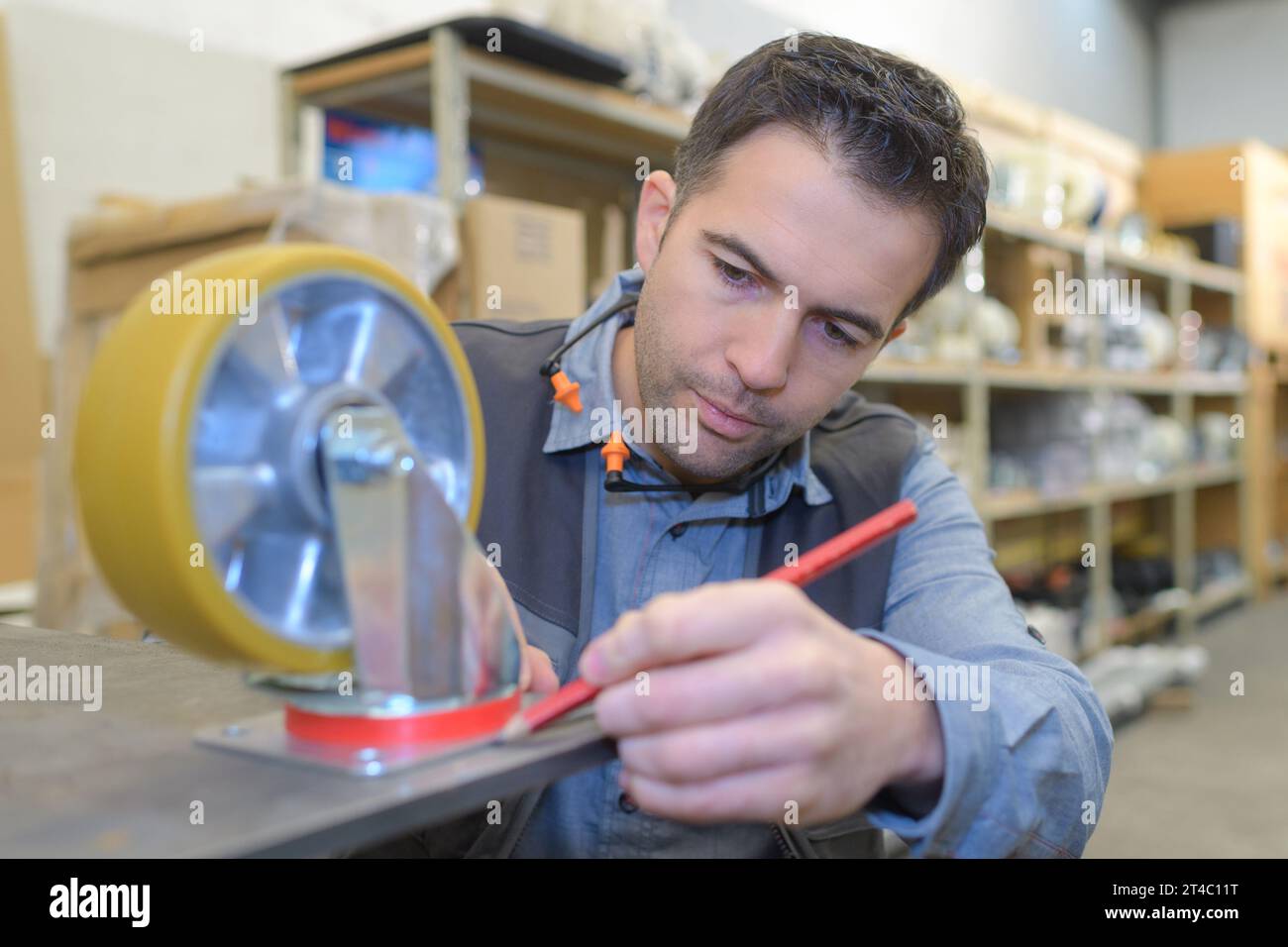 male worker marking position to fix trolley wheel Stock Photo - Alamy