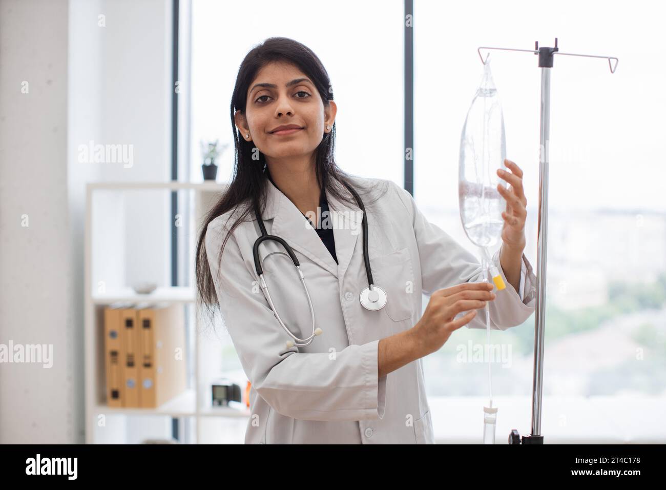 Adult female doctor in white lab coat standing near medical dropper and ...
