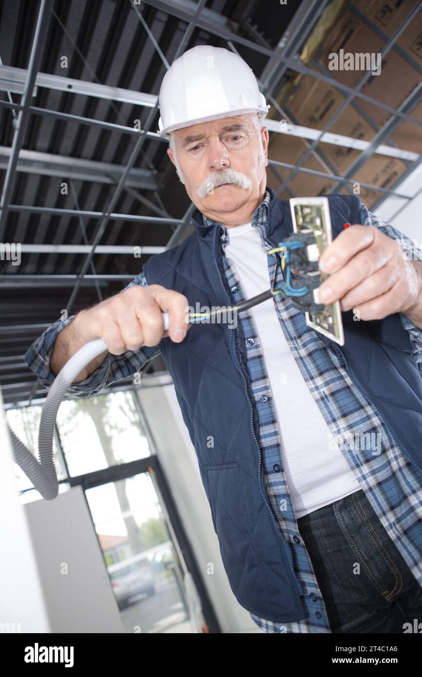 electrician installing wall plugs Stock Photo - Alamy