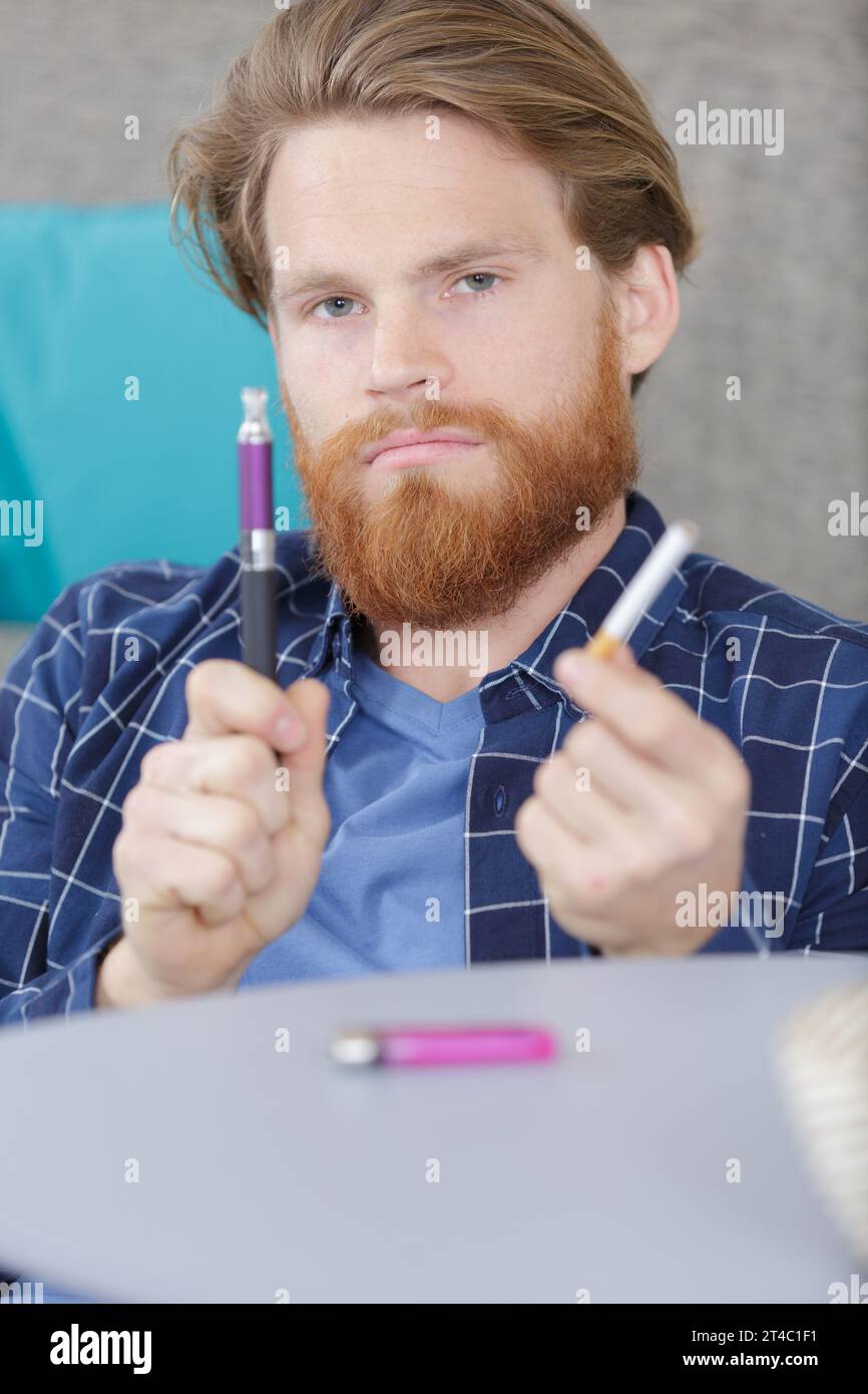 vaping device and cigarettes in the mans hand Stock Photo - Alamy