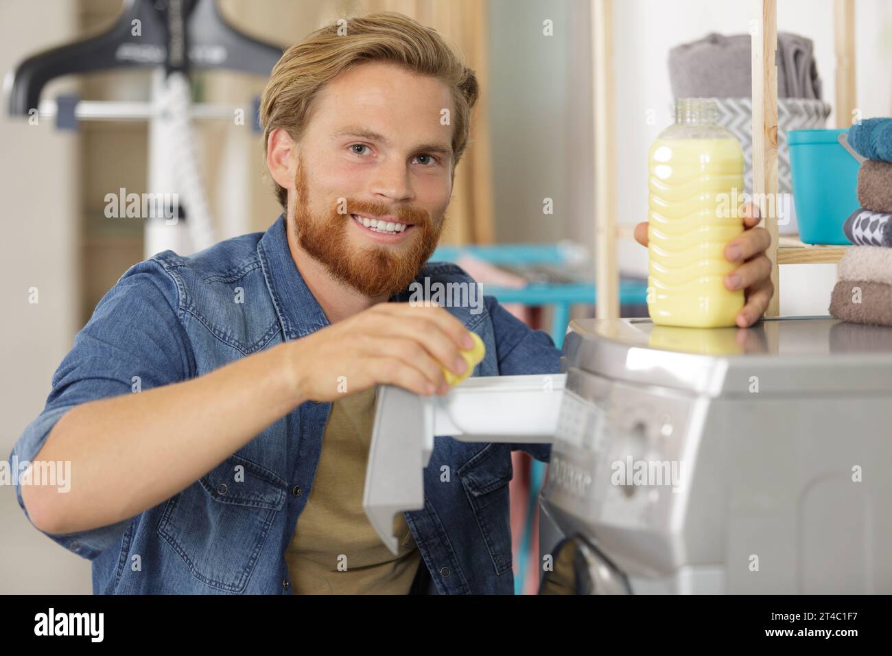picture of man putting liquid detergent in the washing machine Stock ...