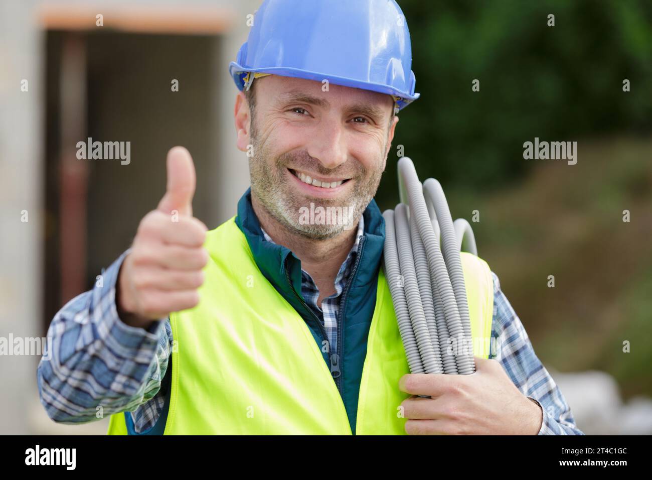 happy builder man laughing and making thumbs up outdoors Stock Photo ...
