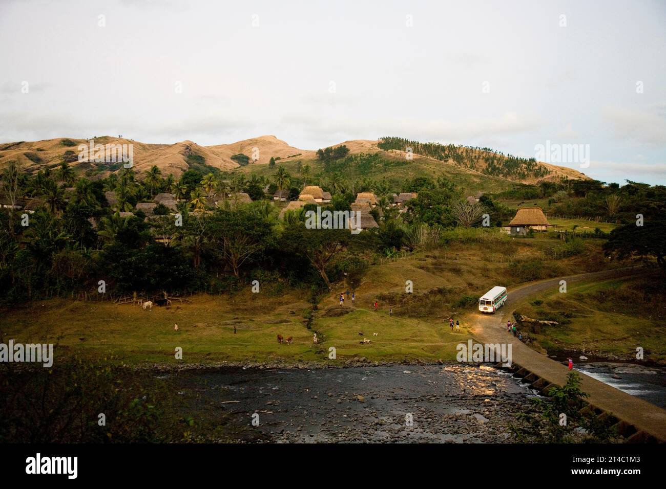 A bus leaves a small village in the highlands of Fiji before crossing a ...