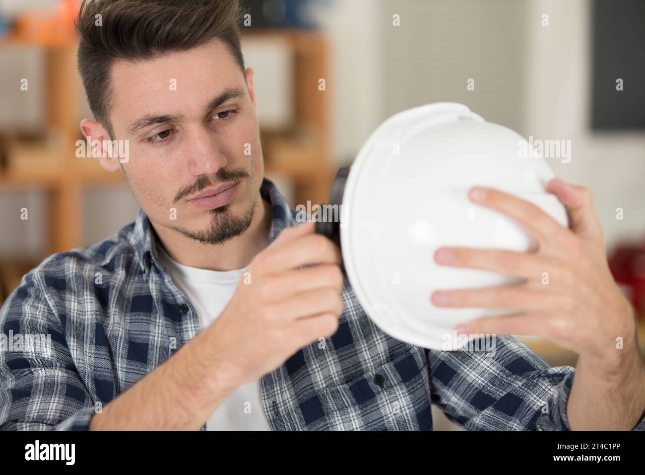 man holding safety helmet on head Stock Photo - Alamy