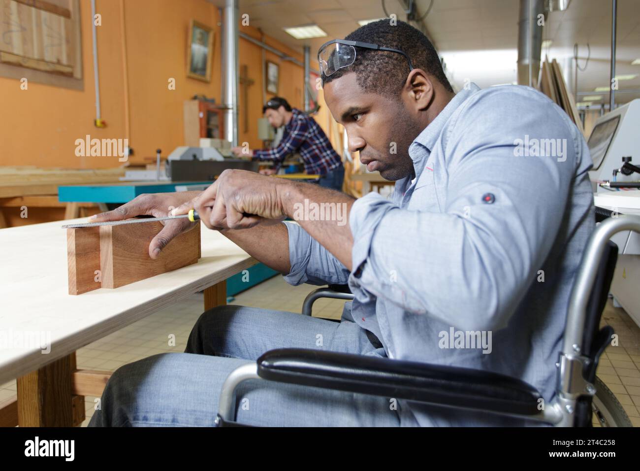 male carpenter in a wheelchair filing Stock Photo - Alamy