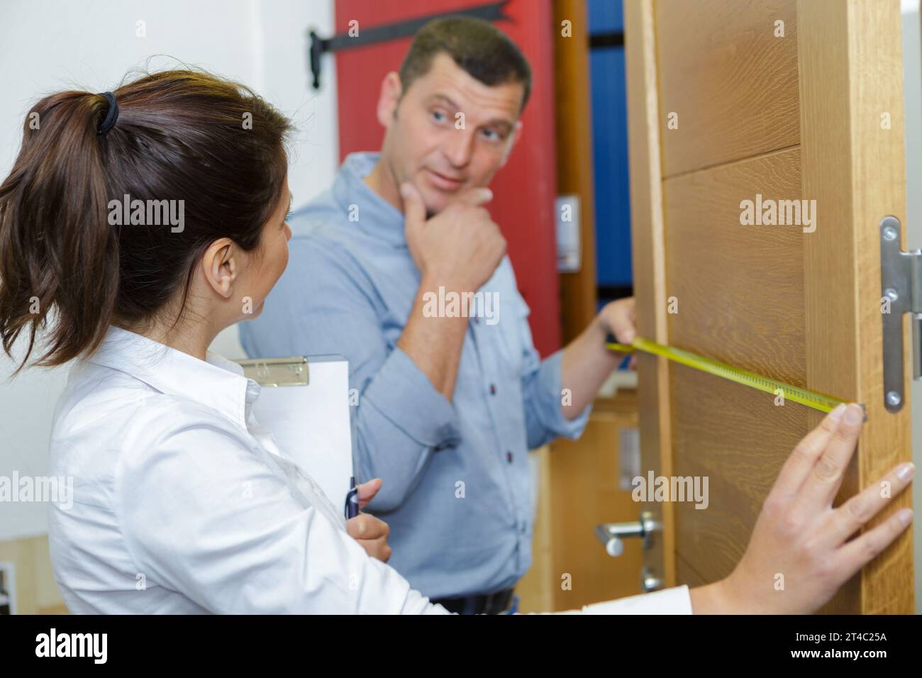 the workers measuring wood door Stock Photo - Alamy