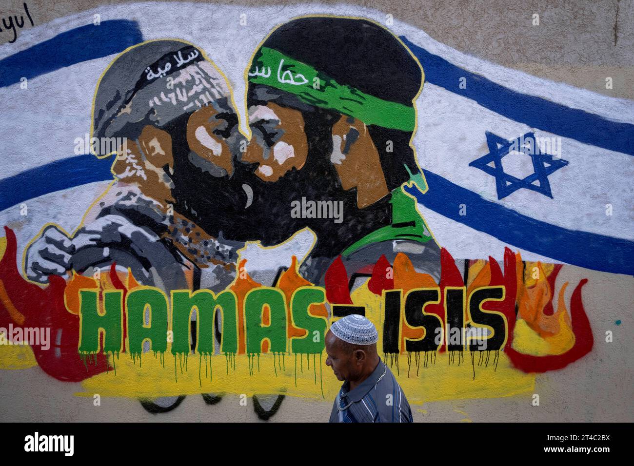 A man walks past a newly painted graffiti that reads Hamas equal ISIS ...