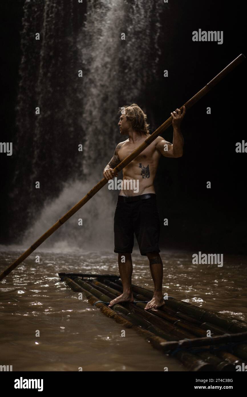 Man on a bamboo raft on a mountain river near a waterfall, Bali Stock ...