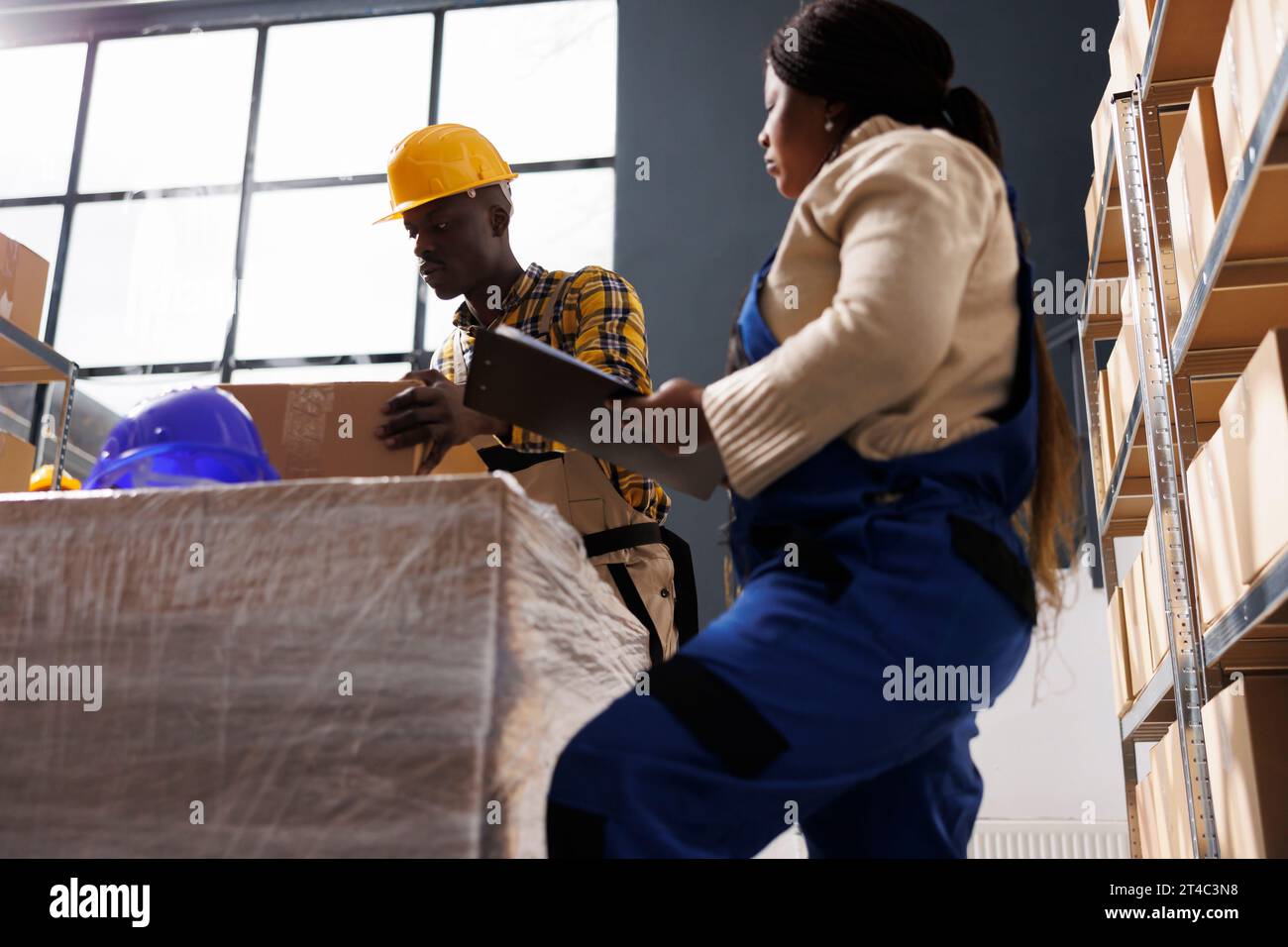 Shipment manager with clipboard supervising customer order package ...
