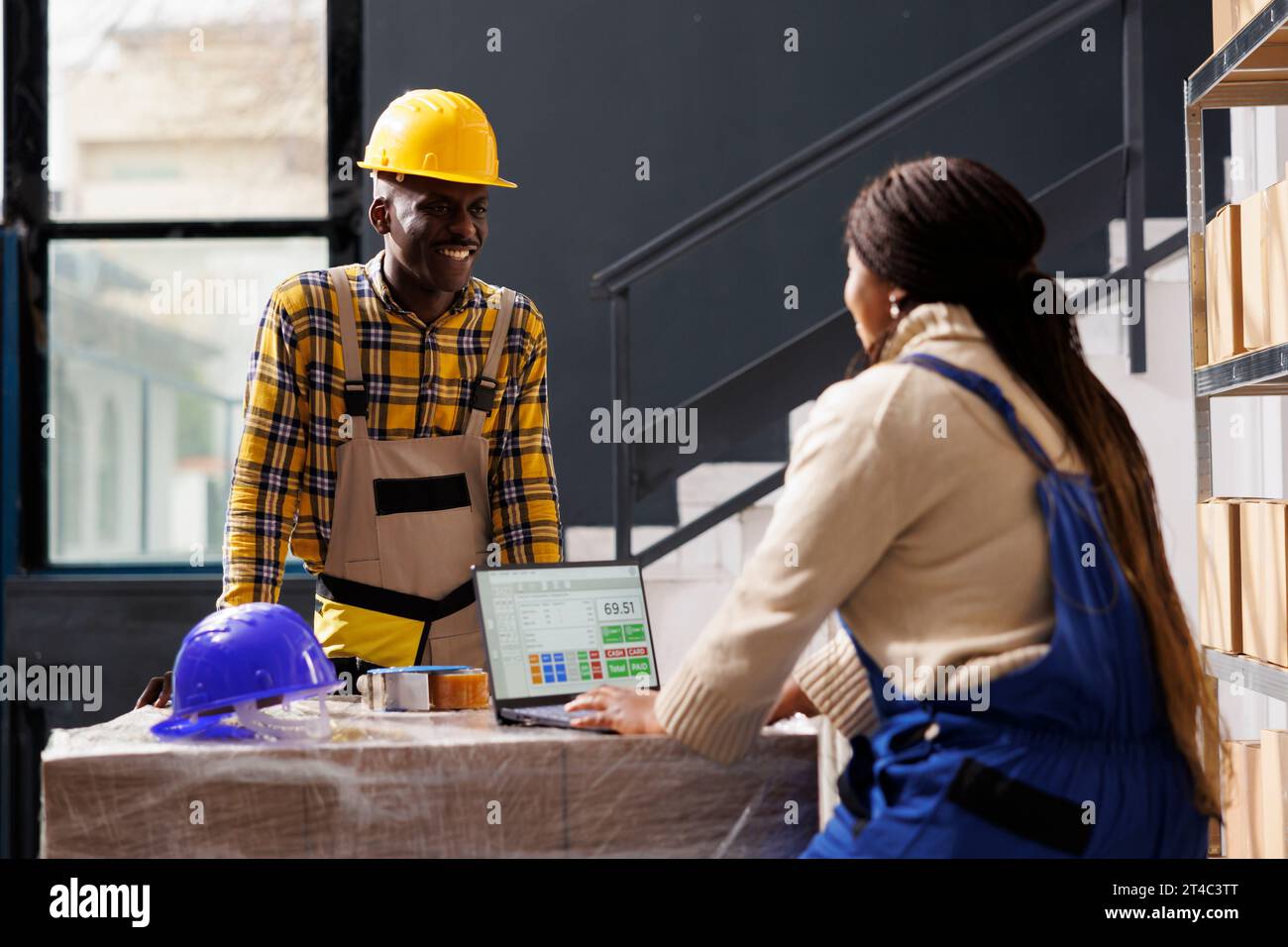 Retail storehouse employees using customer purchase list on laptop to ...