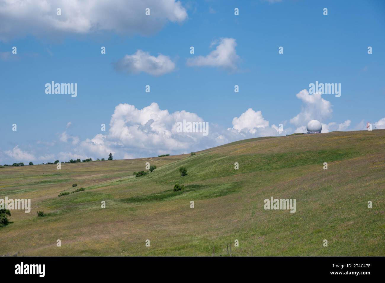 Radome (antenna dome) on the Wasserkuppe with a green meadow and blue ...